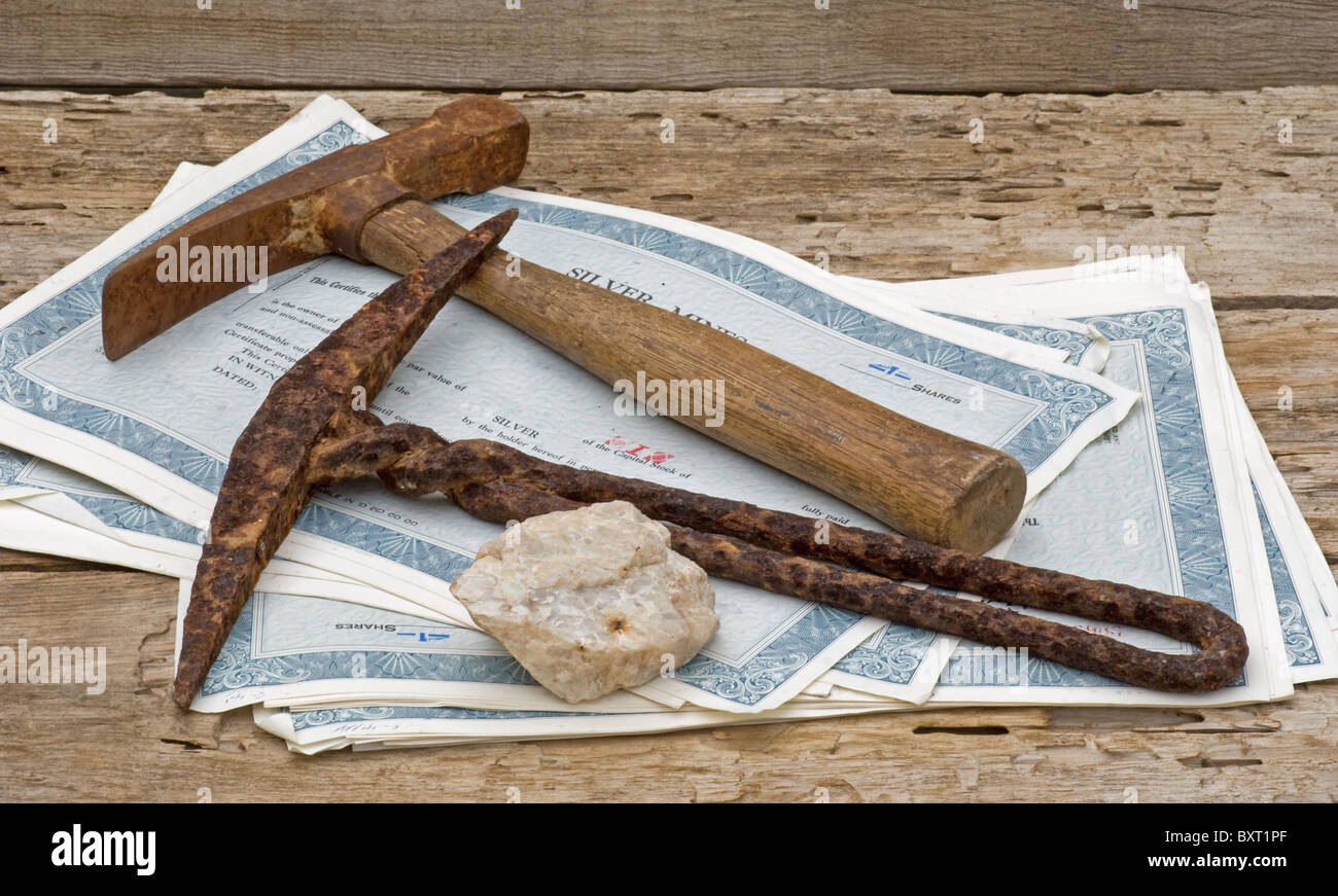 Two old mining prospector tools resting on silver stock certificates ...