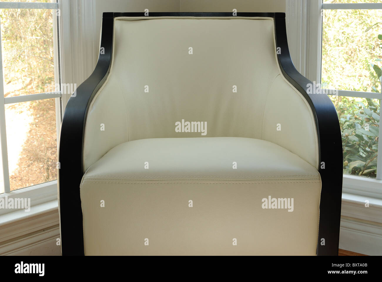 Modern white chair in a window corner Stock Photo - Alamy