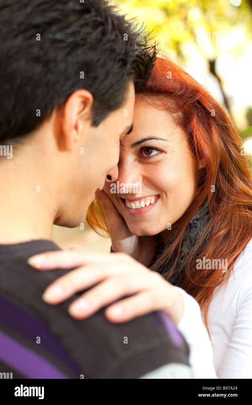 Love and affection between a young couple at the park in autumn season ...