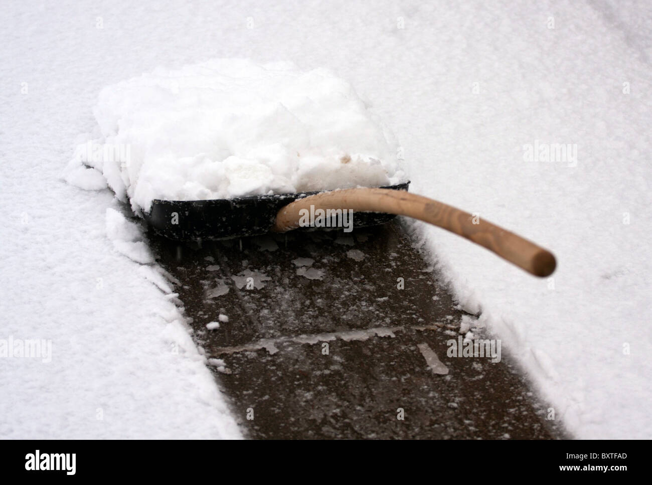 Black plastic snow shovel lying in the fresh fallen snow Stock Photo ...