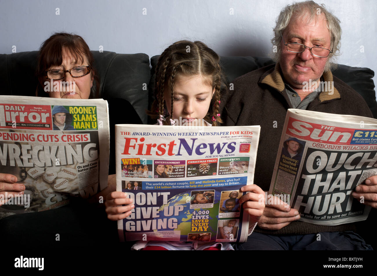 Family members reading British newspapers Stock Photo - Alamy
