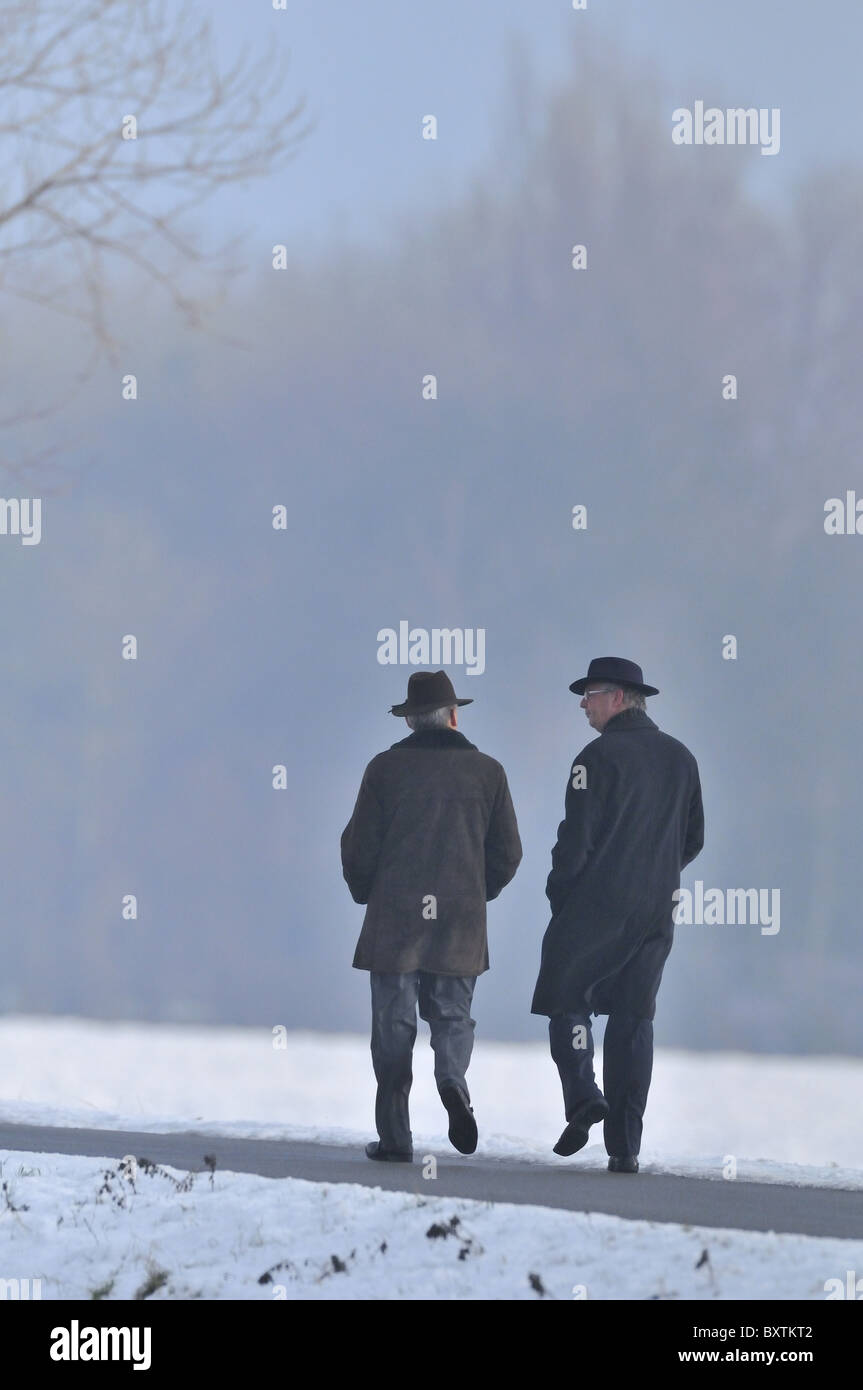 Two men talking seriously in black clothing in de snow Stock Photo - Alamy
