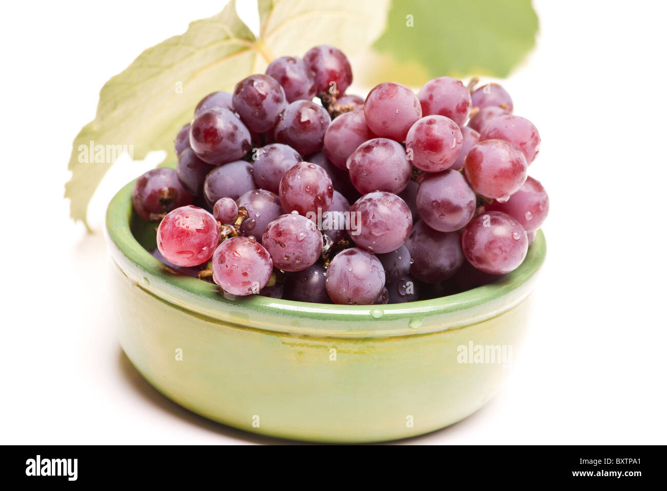 Close-up of red grapes and leaves on white background Stock Photo - Alamy