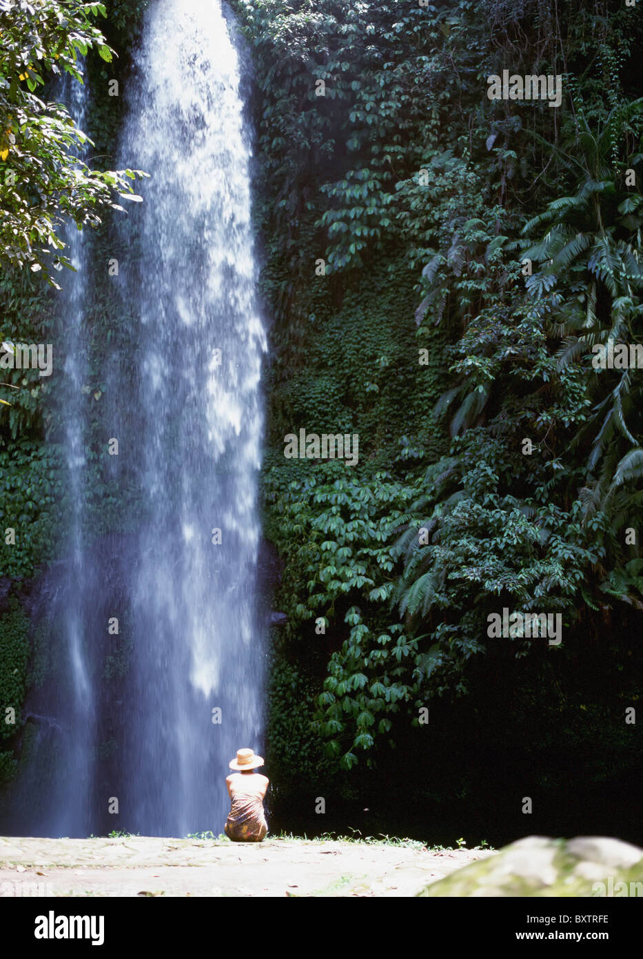 Woman Sitting Beside Waterfall, Sendang Gila Stock Photo - Alamy