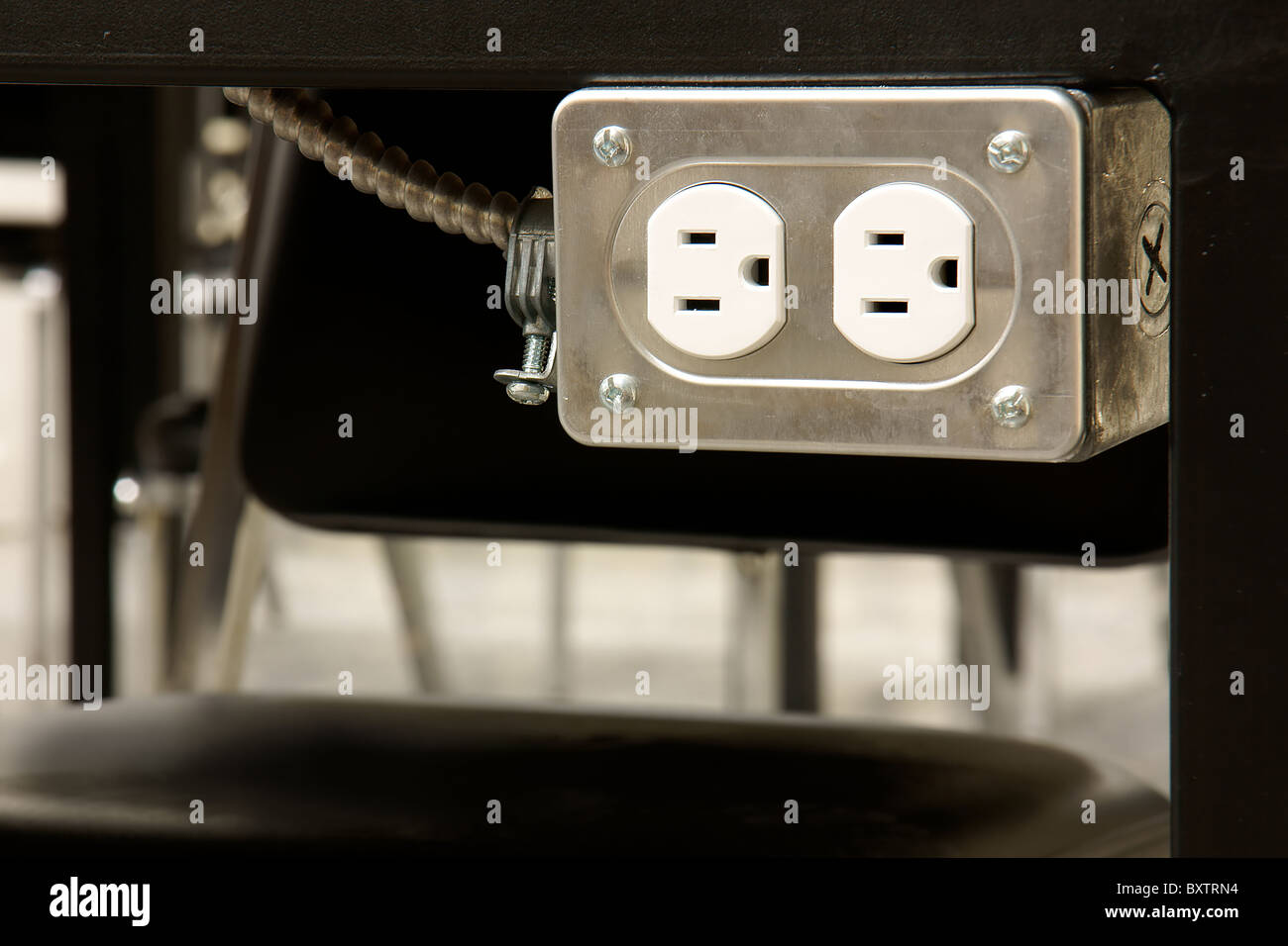 Close-up of an electrical outlet underneath student tabletop in school ...