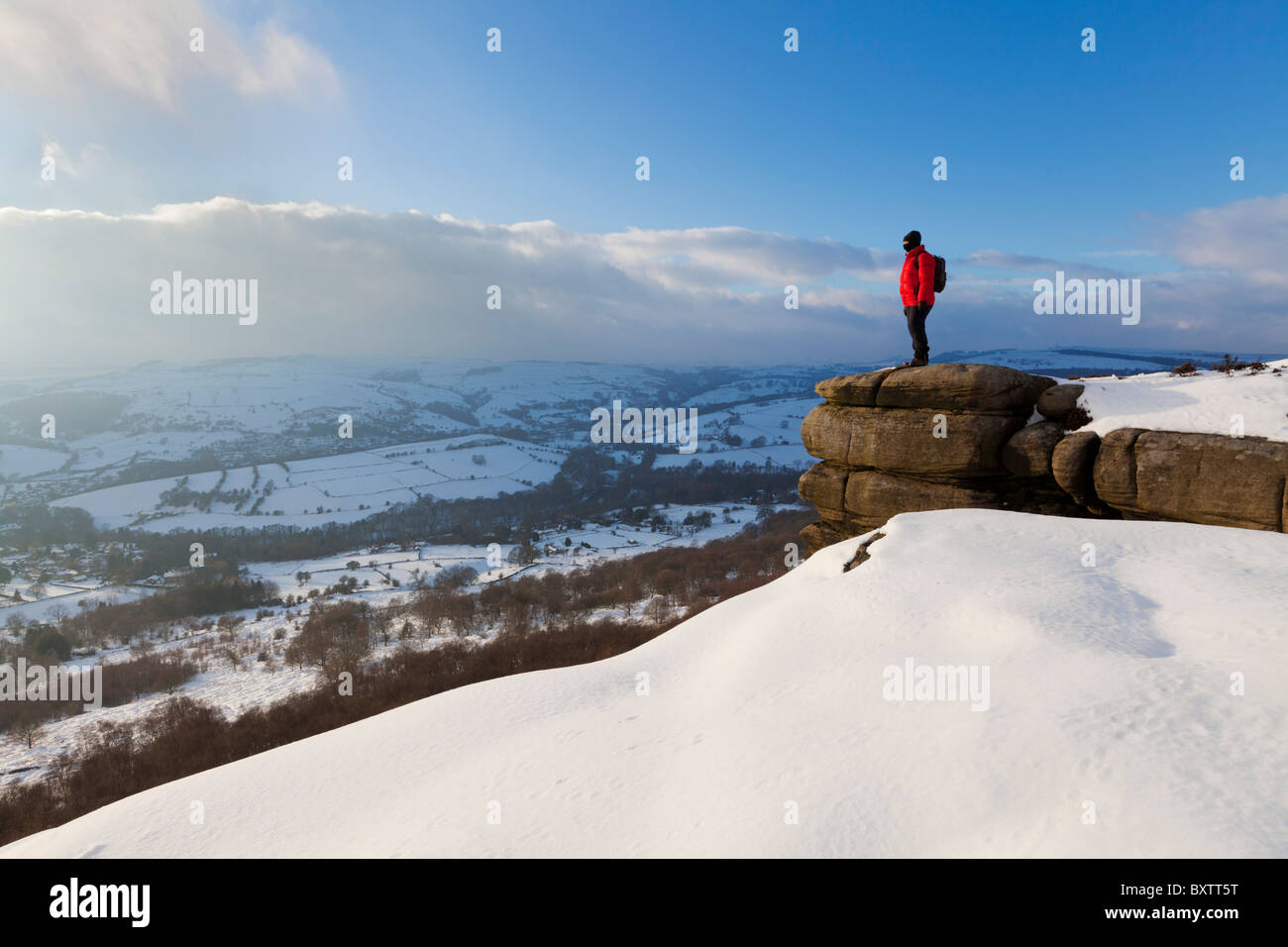 Hiker in the snow on Froggatt edge Derbyshire Peak District National ...