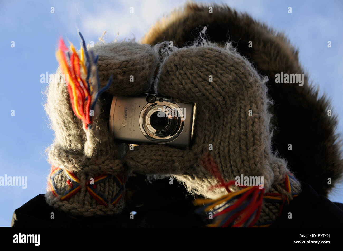 Taking a photo with a compact camera with big mitten gloves Stock Photo ...