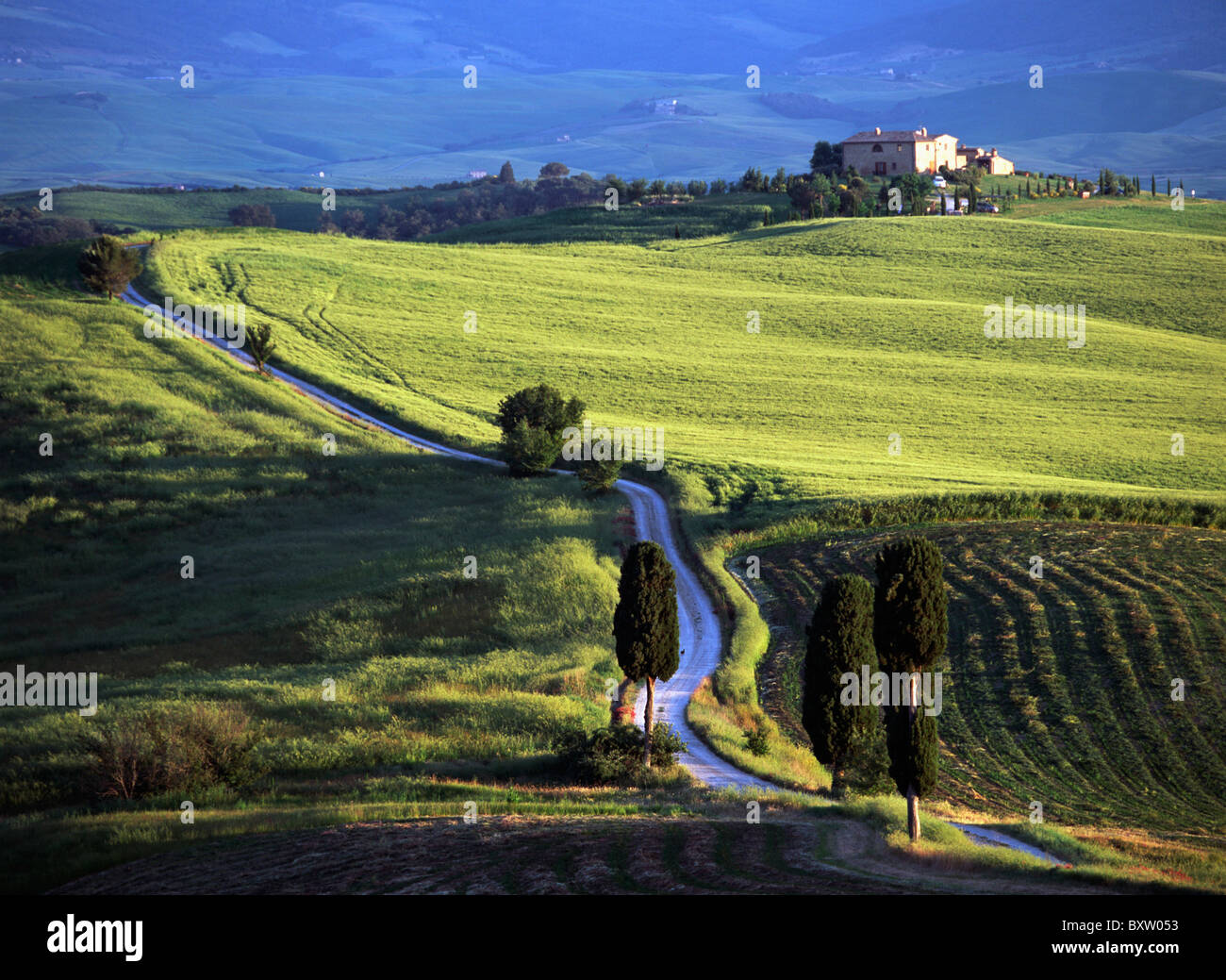 Looking Down Road At Dusk To Old Farmhouse On Hill Top Near Village Of ...