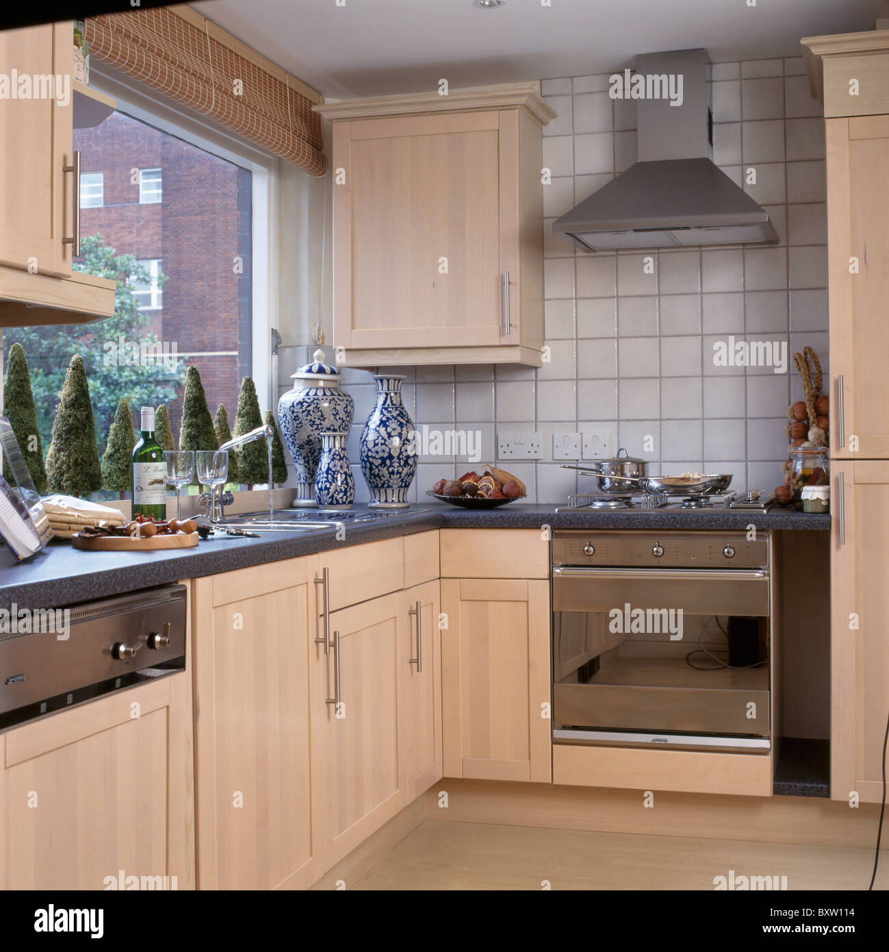 Stainless-steel extractor above steel oven in small kitchen with white ...