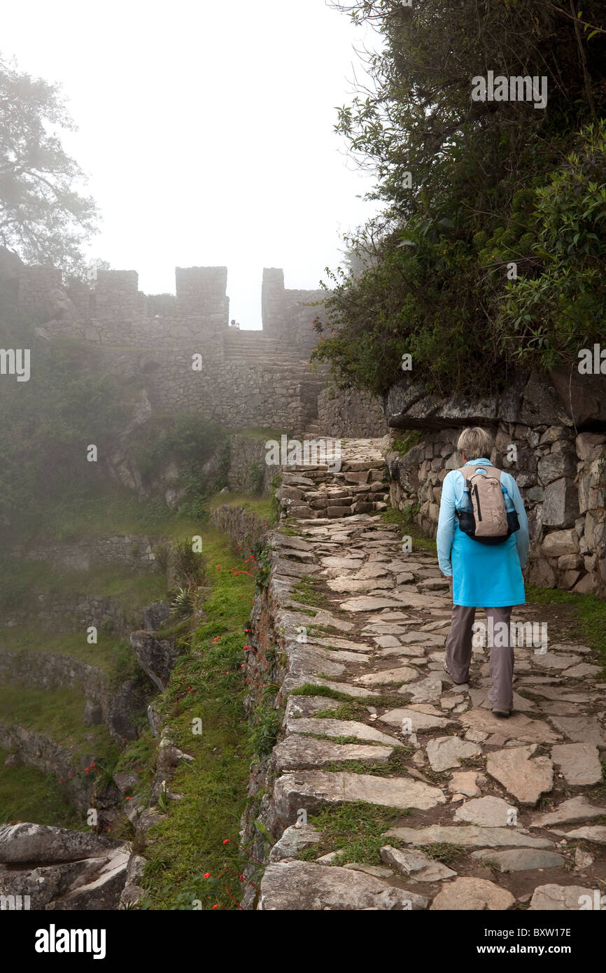 Lady walking up path to Sun Gate at Machu Picchu, Peru, South America ...