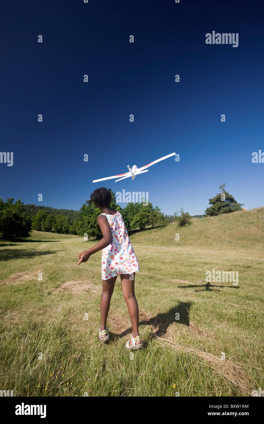 A little black girl playing with a scale model of a plane (France ...