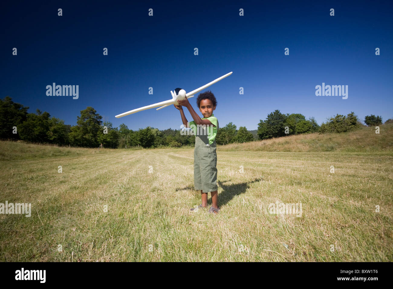 A little black boy playing with a scale model of a plane (Allier ...