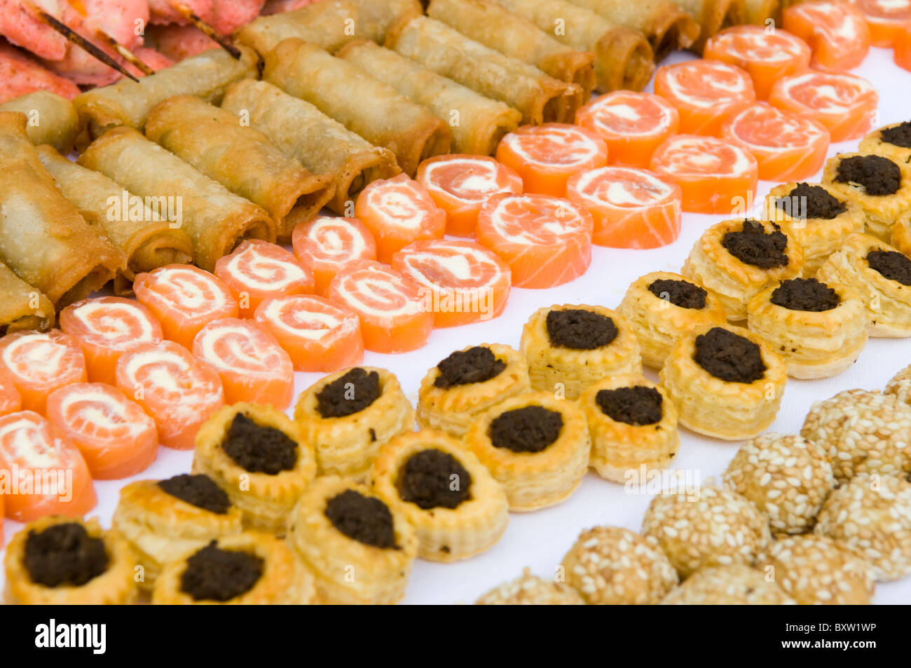 A variety of party canapés in rows on a white tray Stock Photo - Alamy