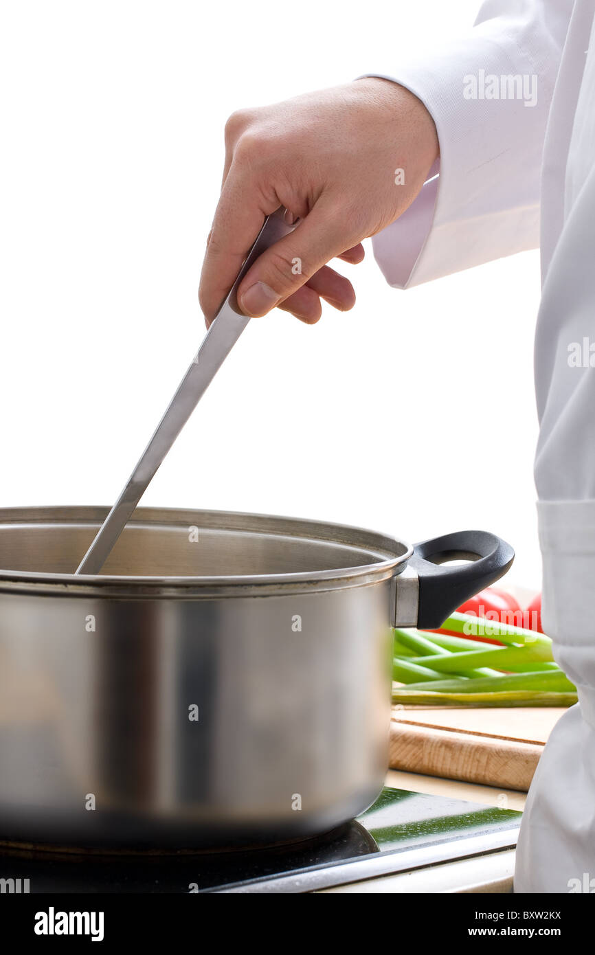 Chef stirring meal in pot on stove Stock Photo - Alamy