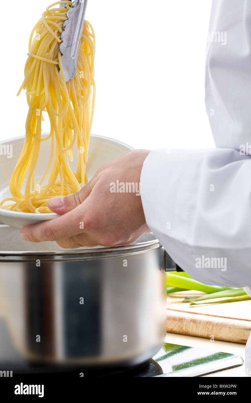 Chef putting spaghetti from pot onto plate Stock Photo - Alamy