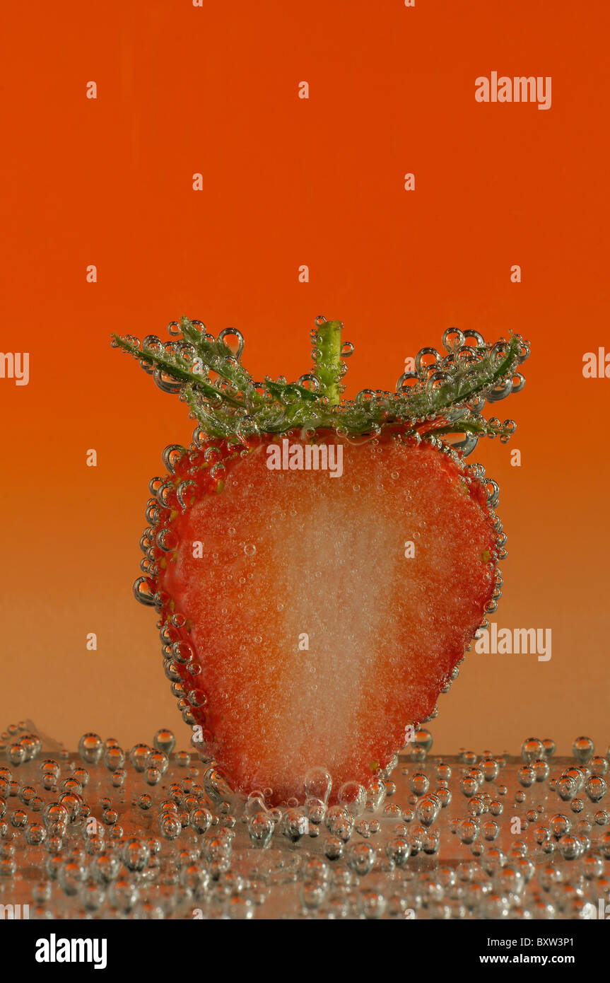 Strawberry in water red background Stock Photo - Alamy