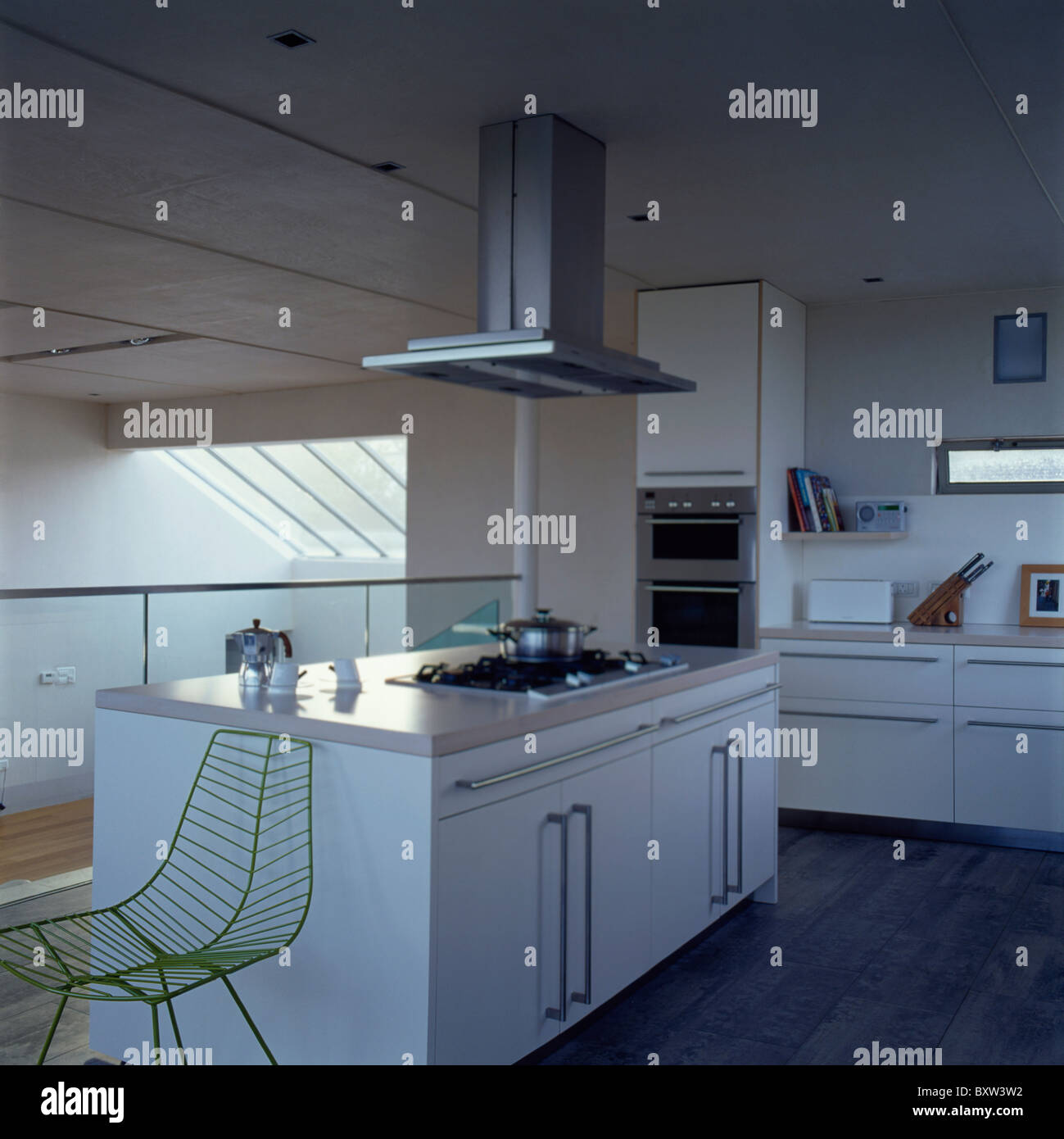 Stainless-steel extractor above hob in island unit in modern white ...