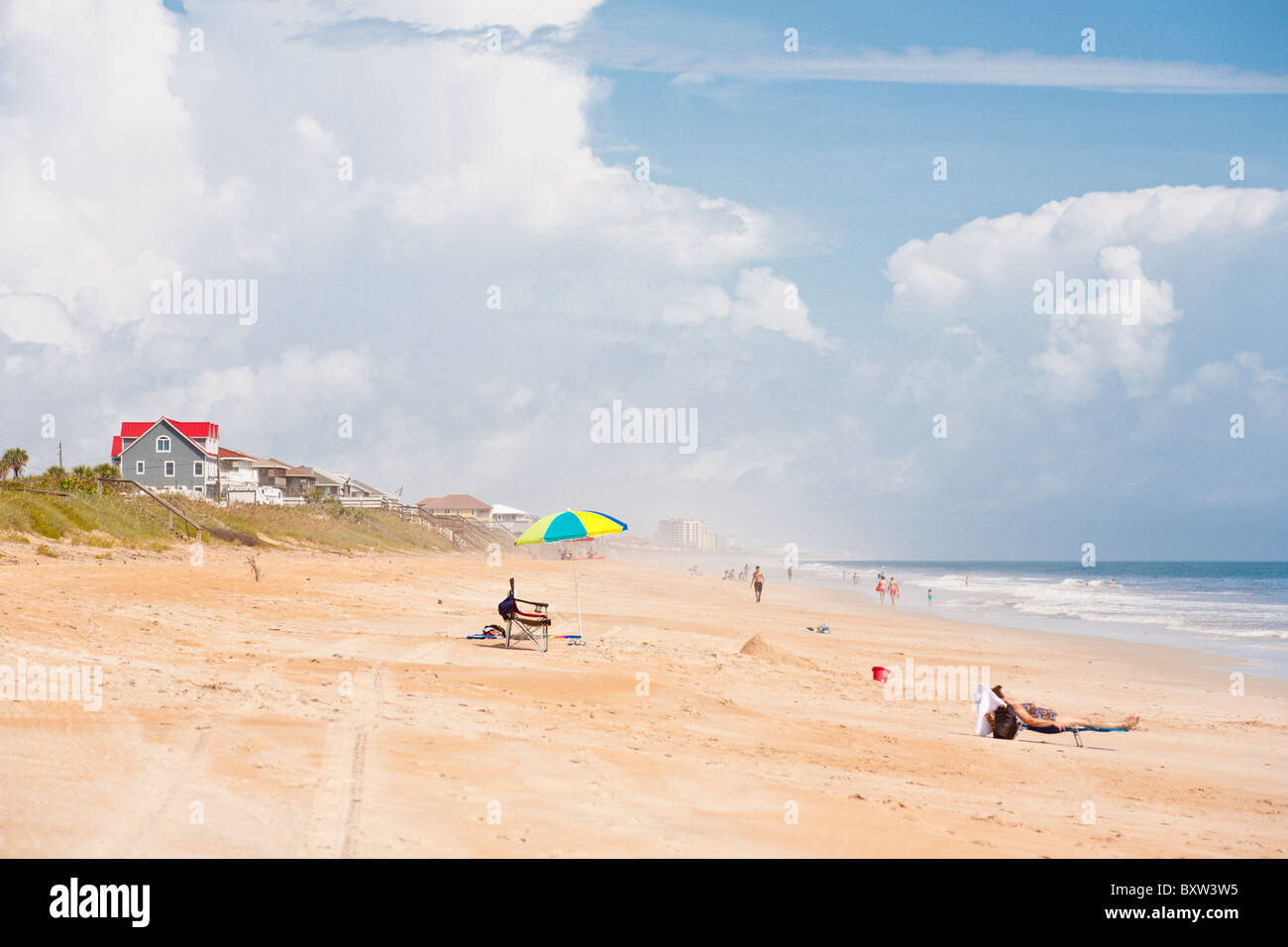 Sunbathers and sun worshipers walk along the beach at Beverly Beach ...