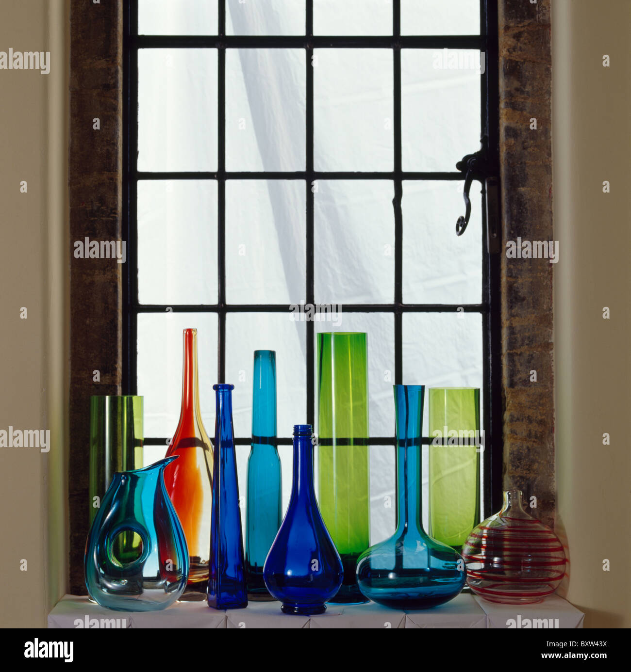 Close-up of window with collection of collection colorful glass bottles ...
