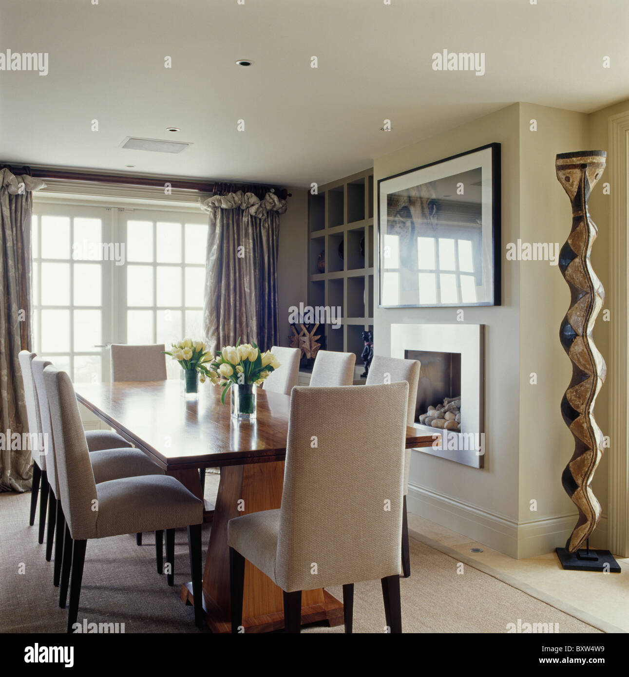 Cream upholstered chairs and wood table in traditional dining room with ...
