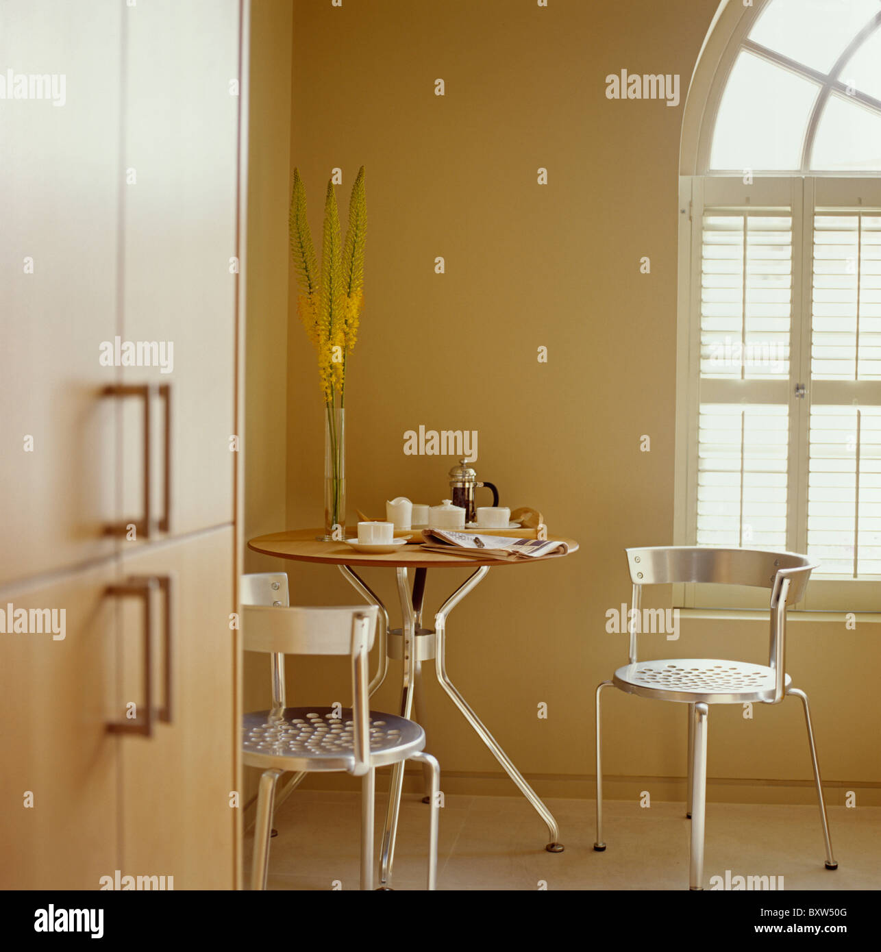 Small circular metal table and metal chairs in dining corner of modern ...