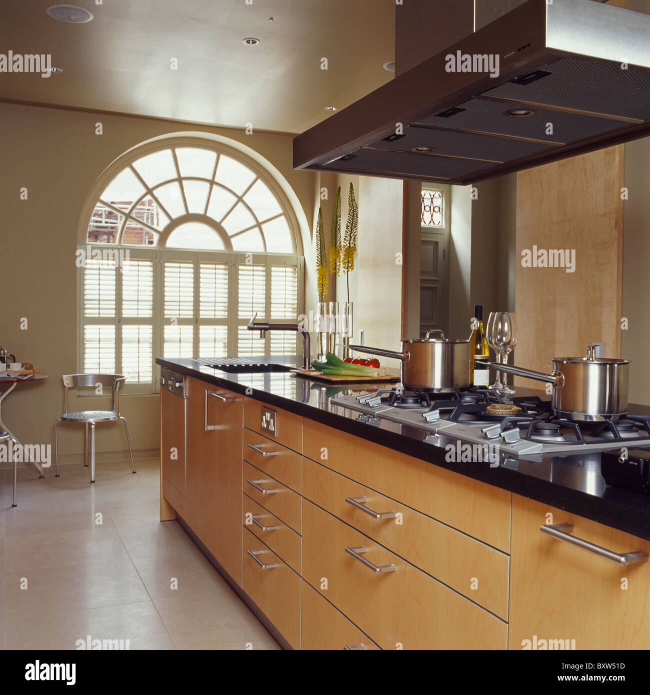 Large extractor above hob in pale wood fitted unit with granite worktop ...
