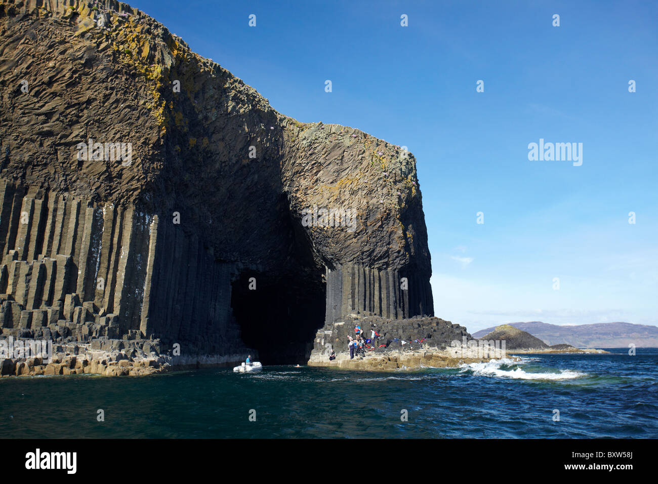 People and boat at entrance to Fingal's Cave, Staffa, off Isle of Mull ...