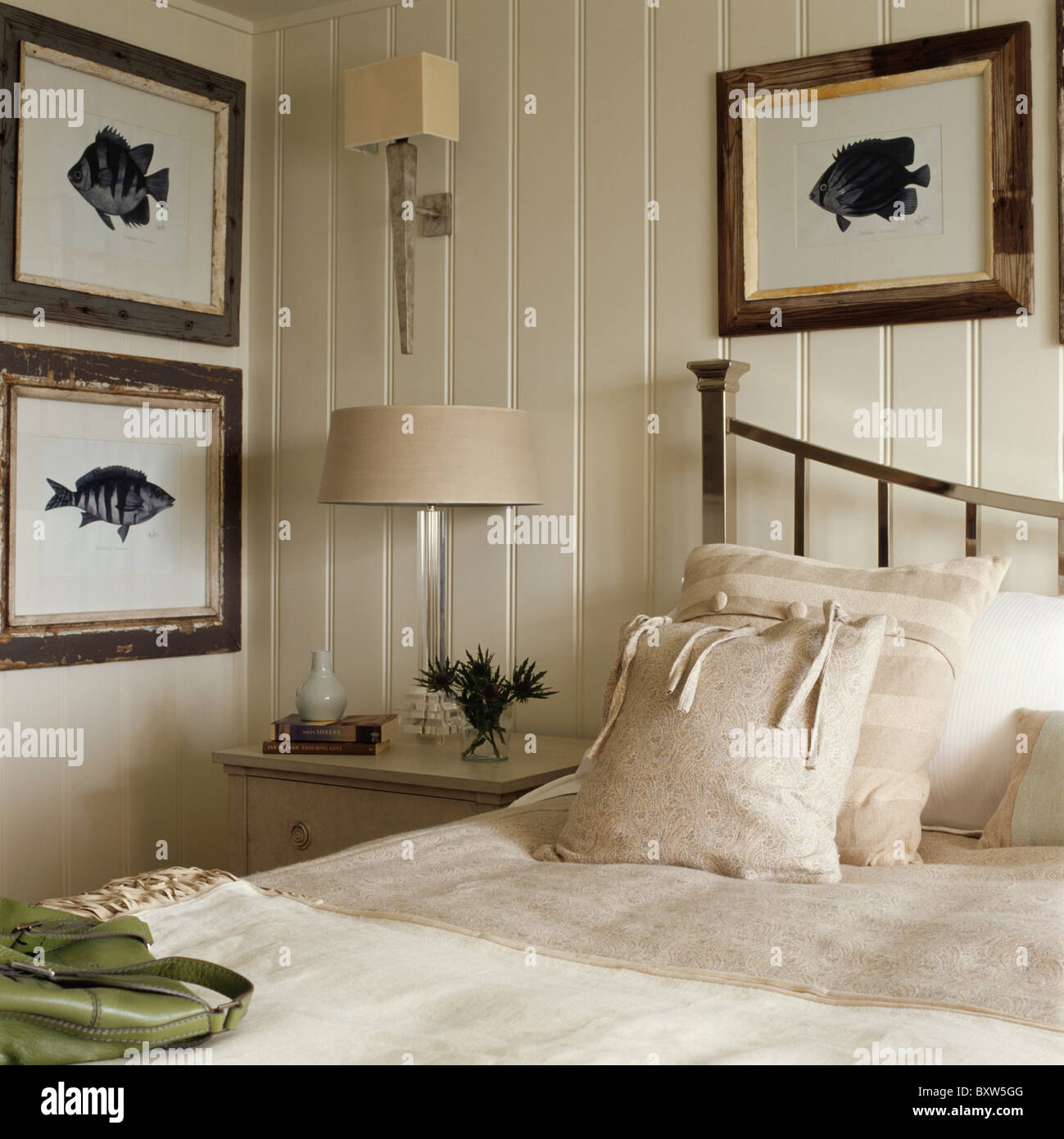Fish pictures on walls of cream paneled cottage bedroom with cream ...