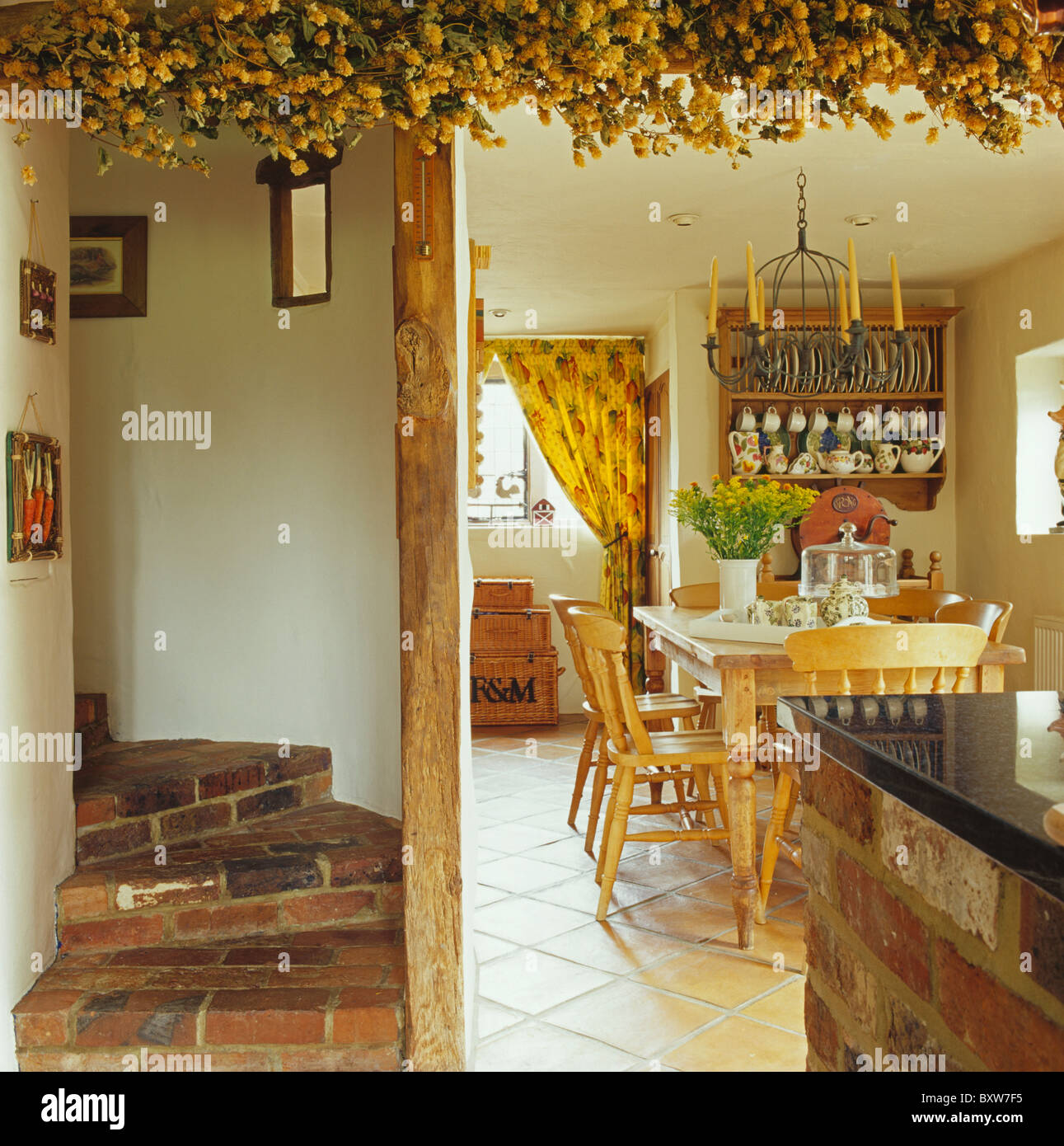 Dried hop vine on ceiling of cottage kitchen dining room with brick ...