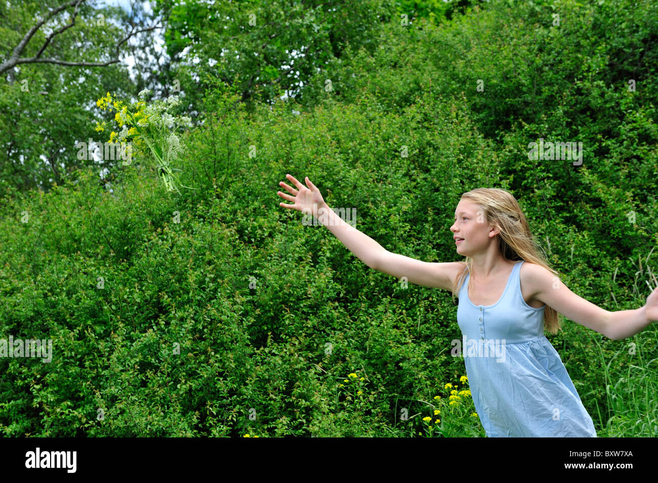Young blond girl throwing a bouquet of flowers Stock Photo - Alamy