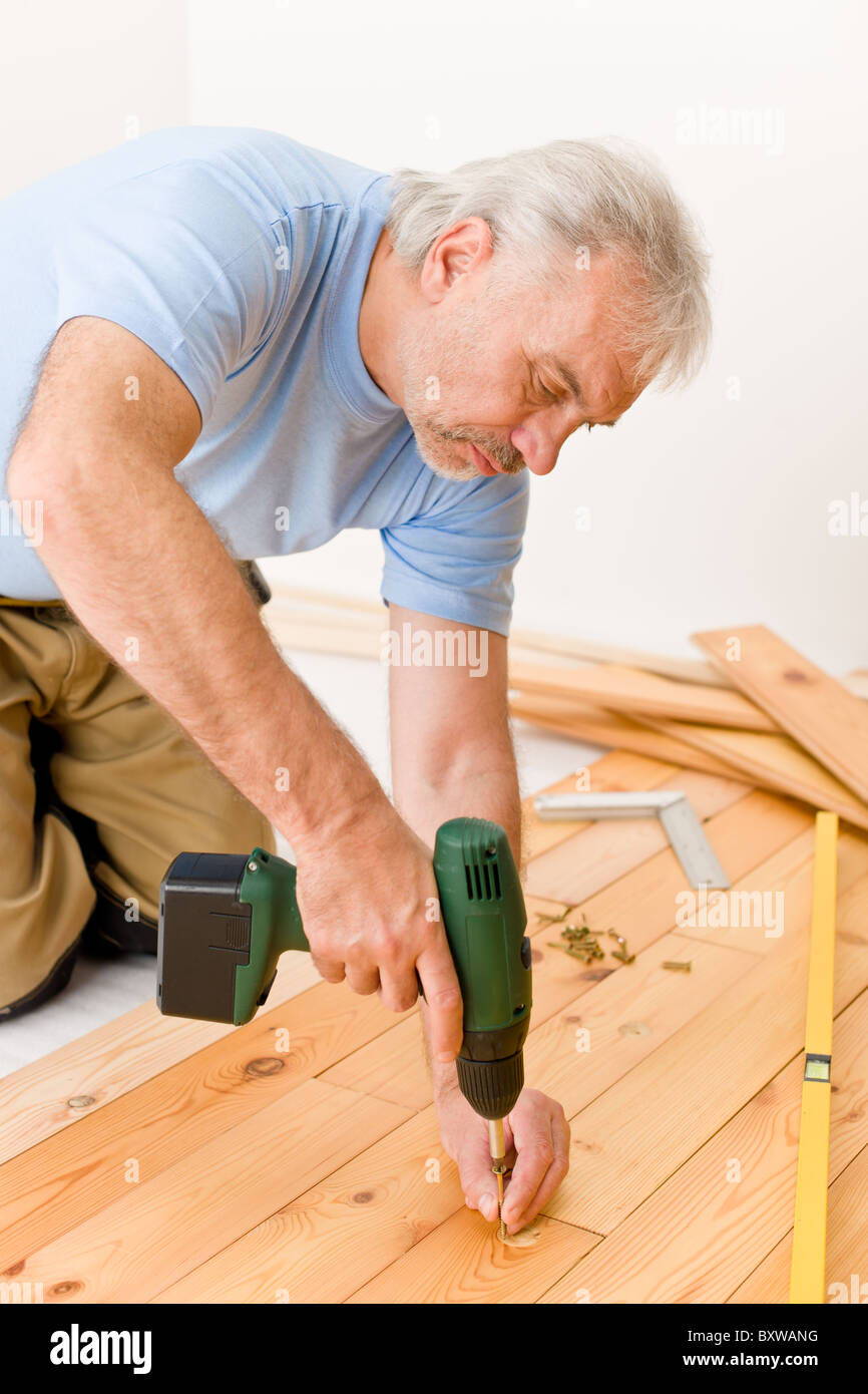 Home improvement - handyman installing wooden floor home Stock Photo ...