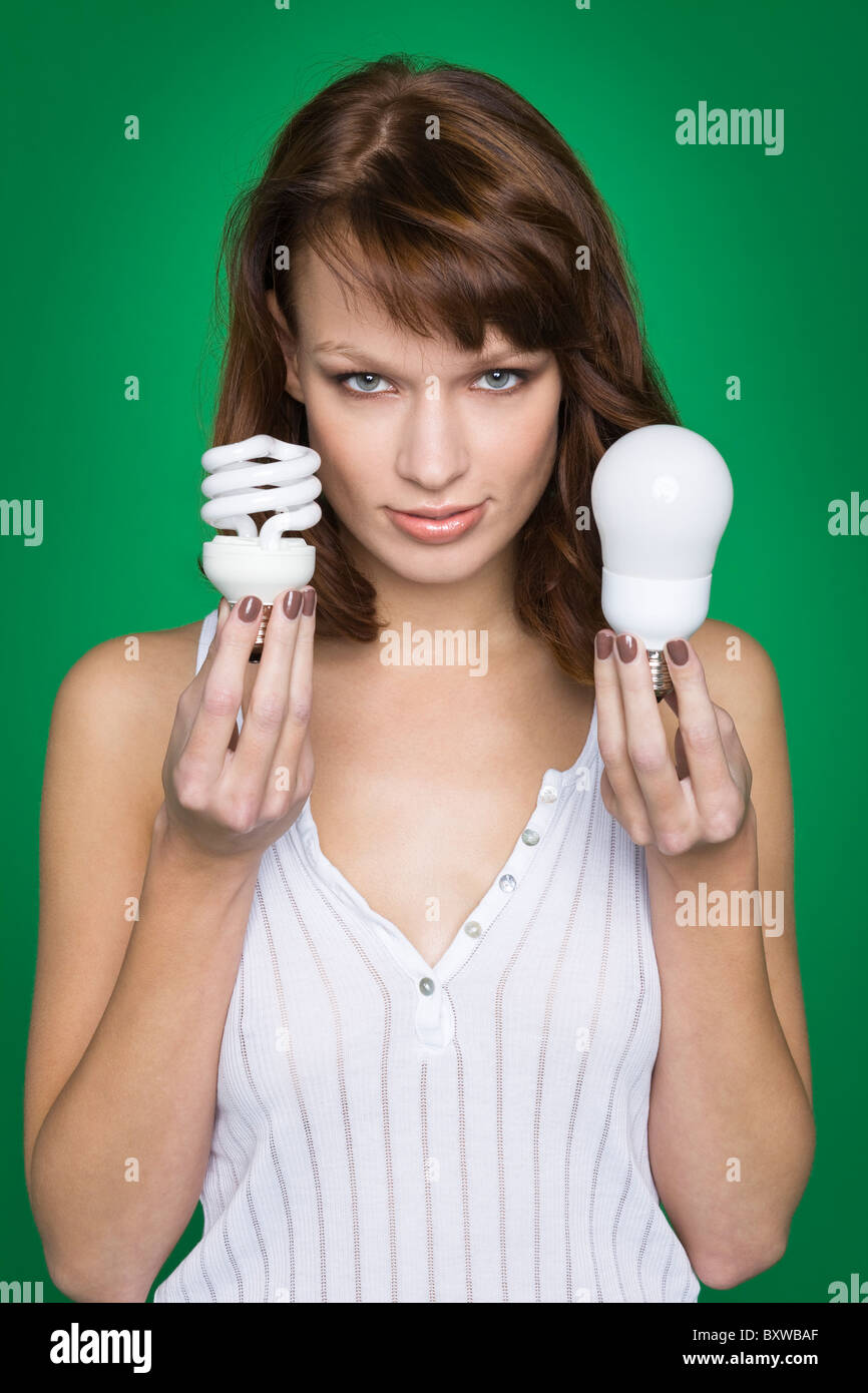 Young woman holding two light bulbs Stock Photo - Alamy