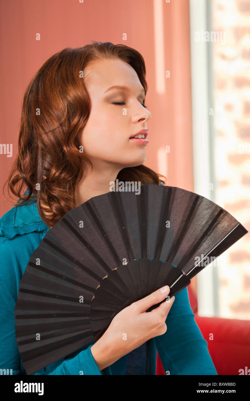 Young woman using fan Stock Photo - Alamy