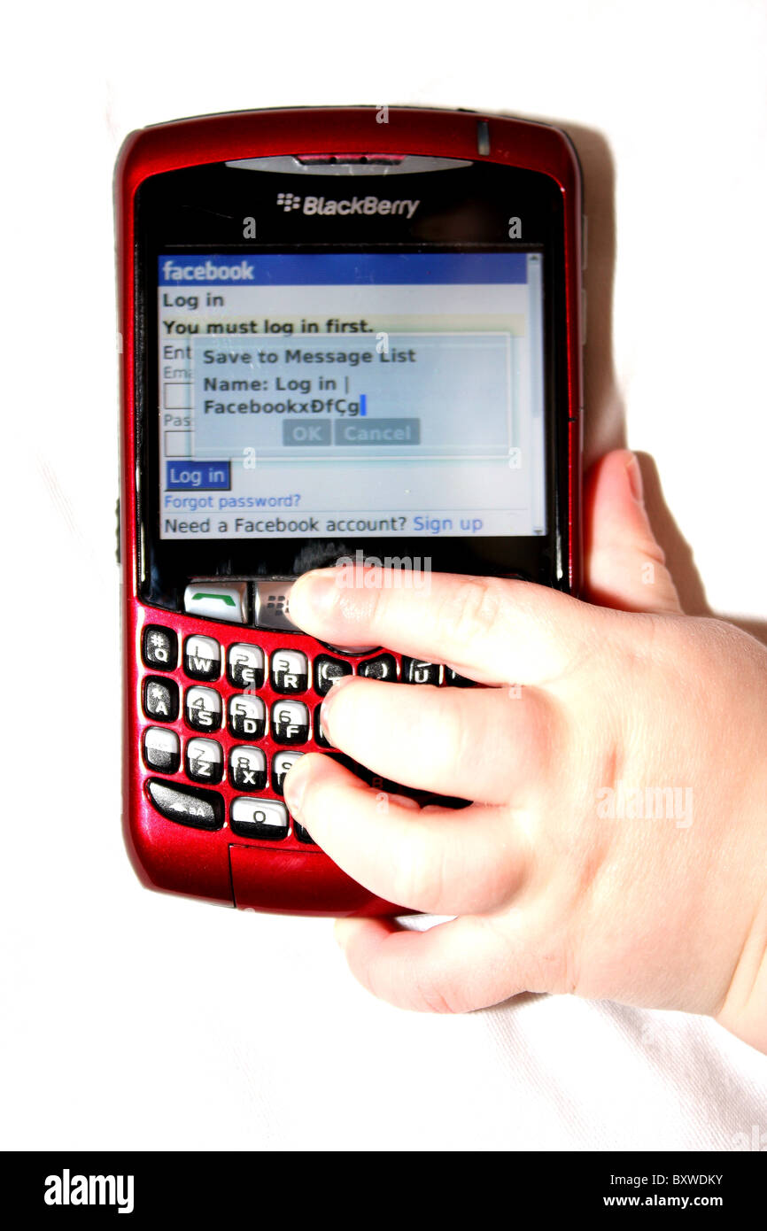 A white Caucasian baby toddlers hand using a red Blackberry mobile ...
