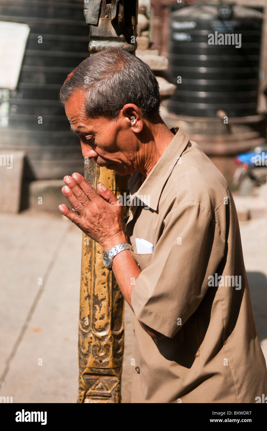Buddhist pilgrim praying at a shrine in Durbar Square in Kathmandu ...