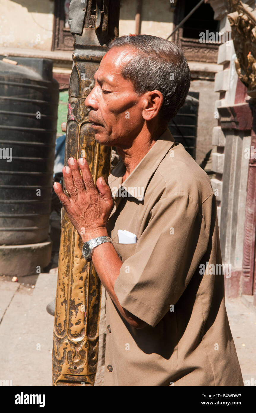 Buddhist pilgrim praying at a shrine in Durbar Square in Kathmandu ...