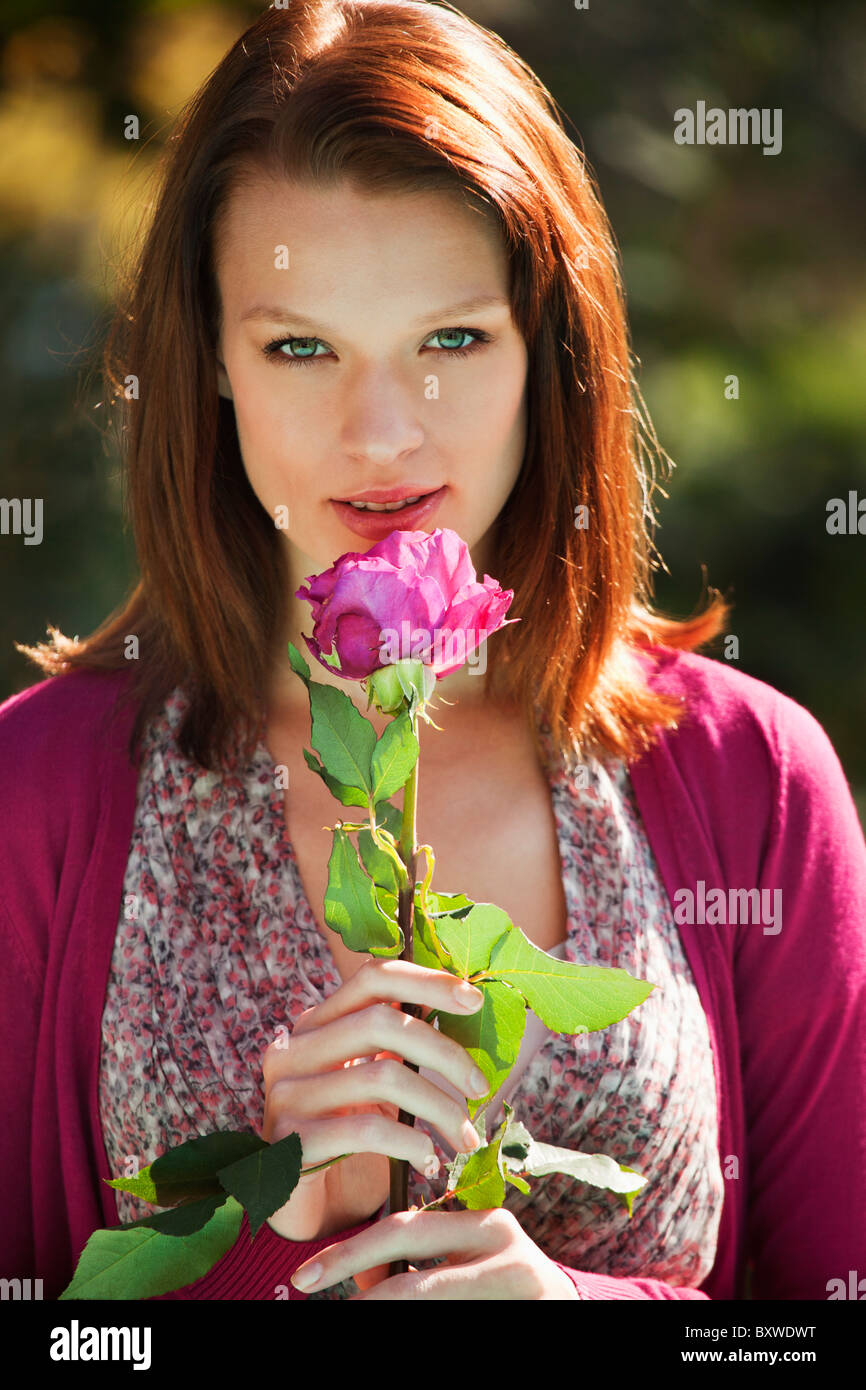 Young woman smelling rose Stock Photo - Alamy