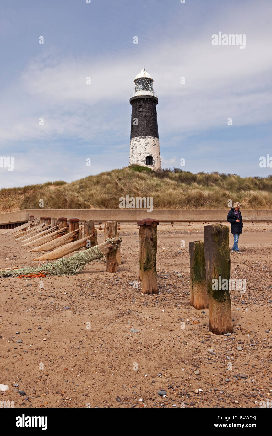 The beach at Spurn Point showing the lighthouse and sea defence remains ...