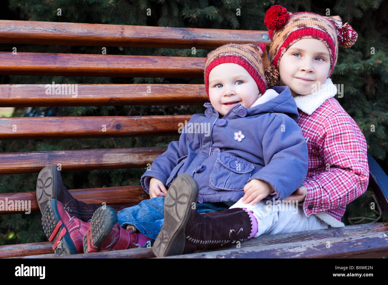 Children sitting on a bench outdoor Stock Photo - Alamy