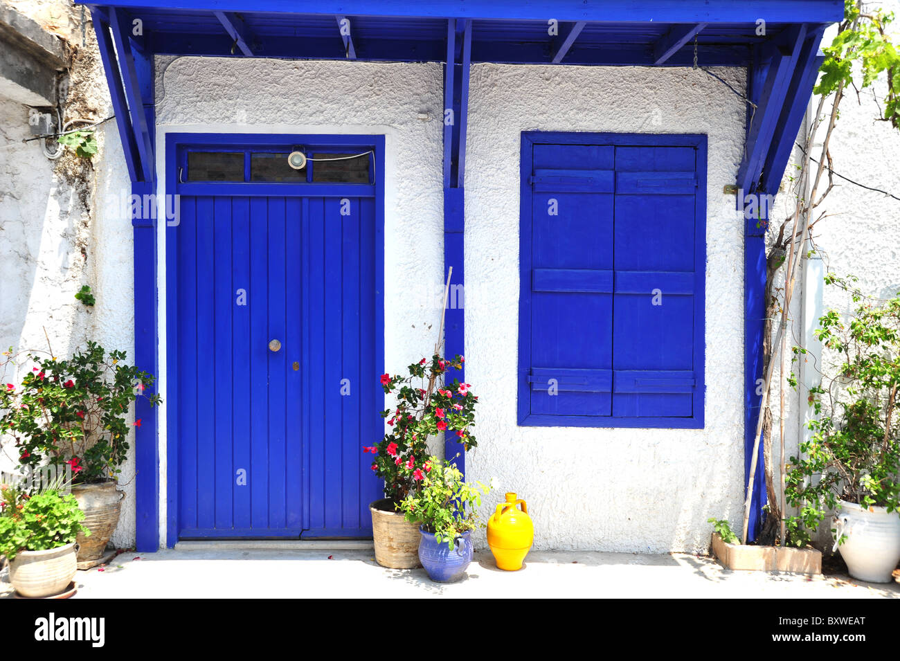 Traditional white painted building and blue door and windows in Greece ...