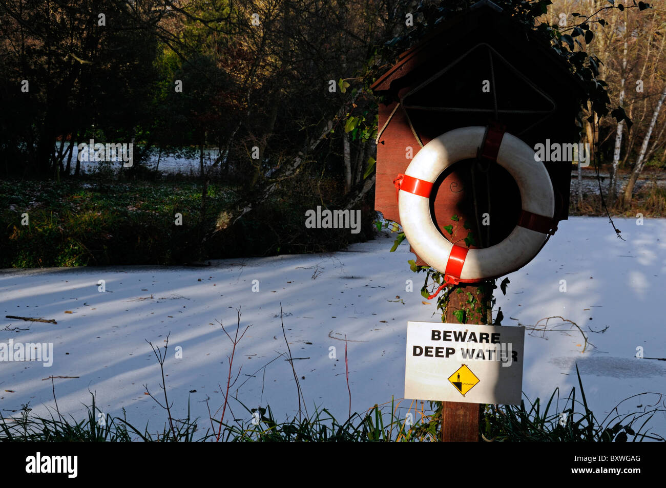 life buoy ring life ring beside frozen pond beware of deep water sign ...