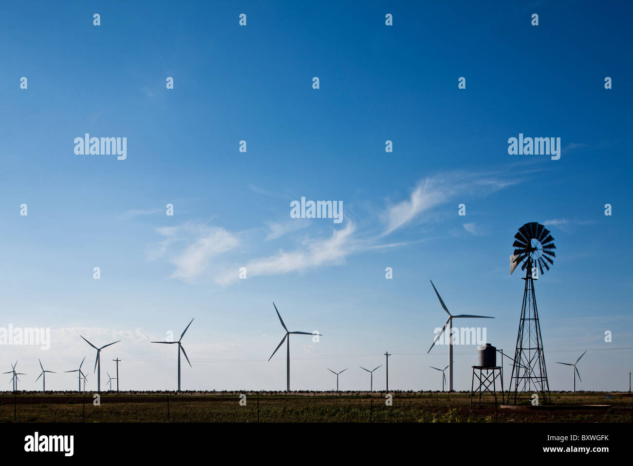 USA, Texas, Vega, Old rancher’s windmill and line of wind generating ...