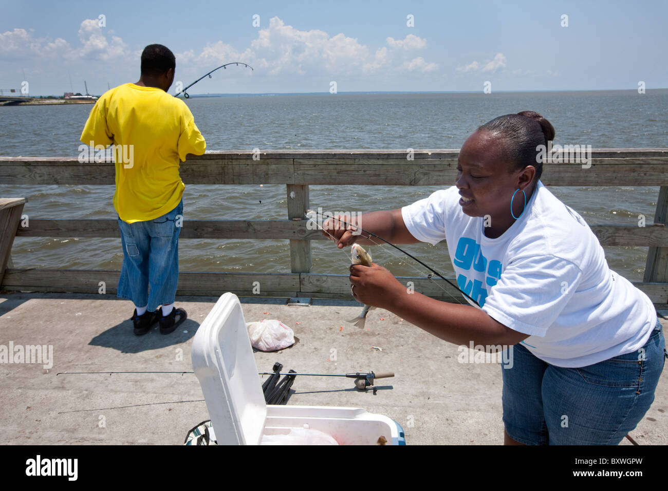 USA, Alabama, Mobile, African-American family fishing from dock along ...