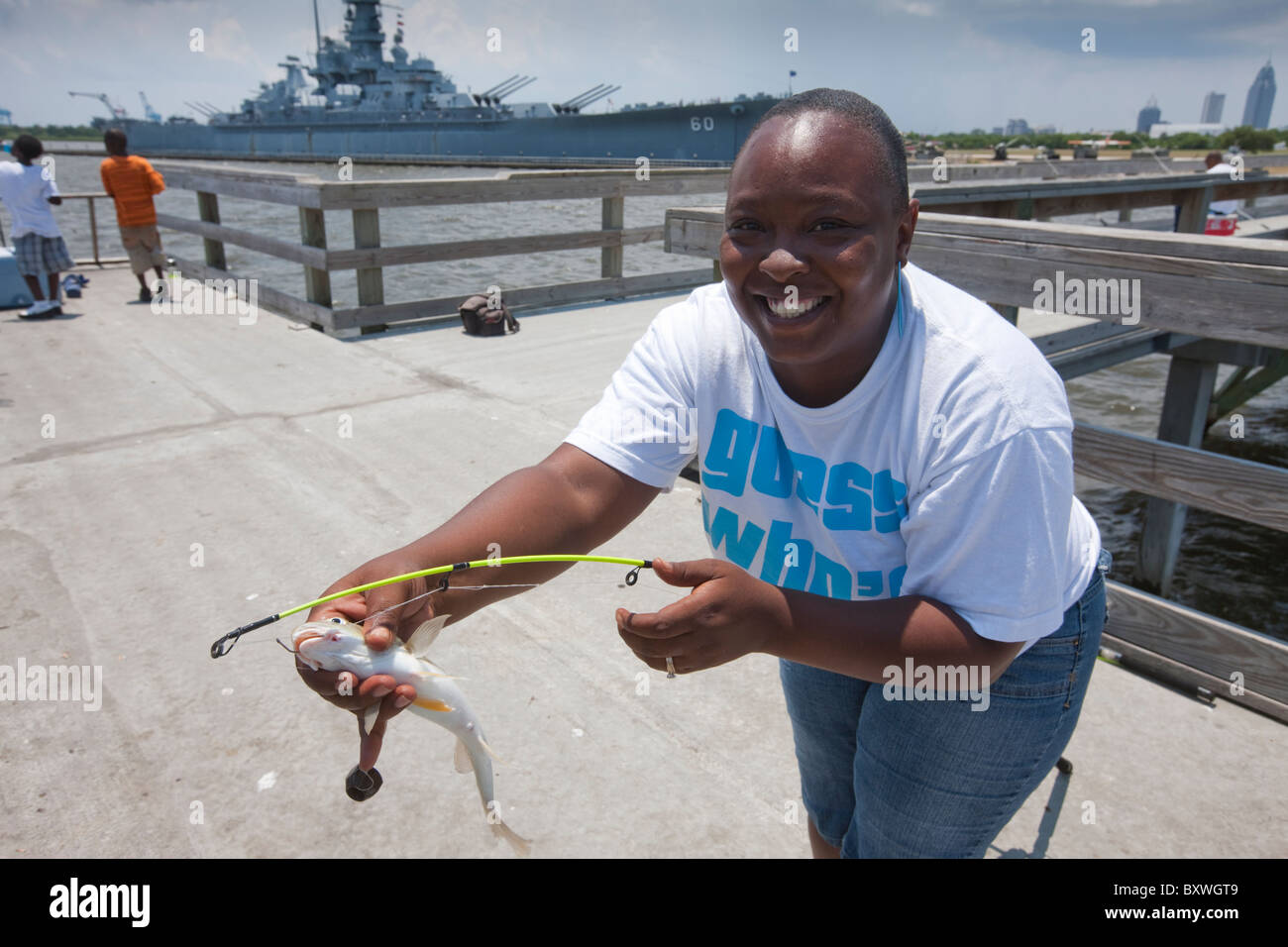 USA, Alabama, Mobile, African-American woman holding catch while ...