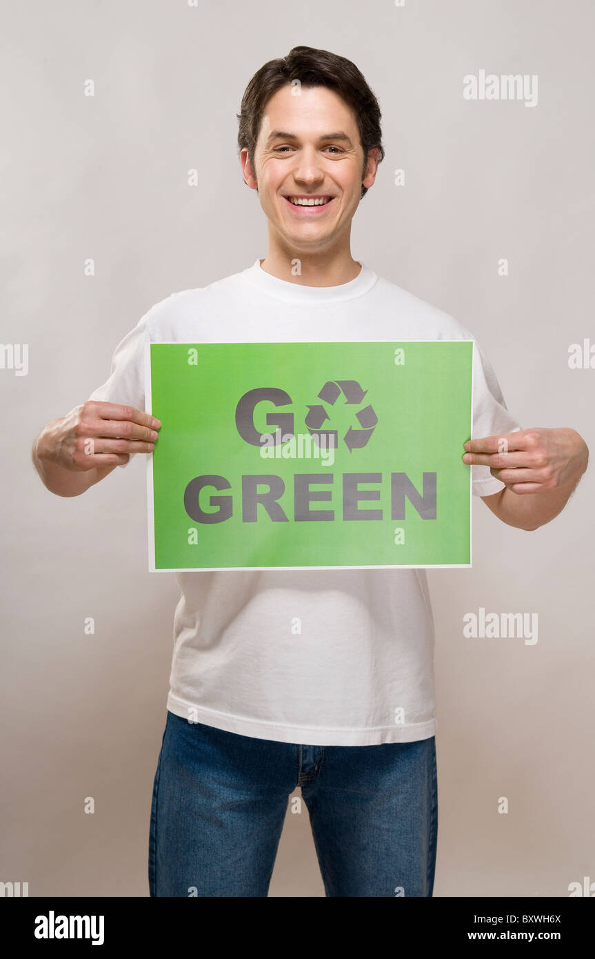 Man holding "Go green" sign Stock Photo - Alamy