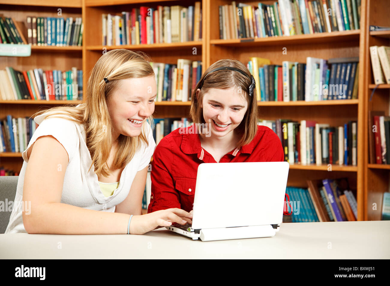 Teen girls using a netbook to do research in the library. Room for Text ...