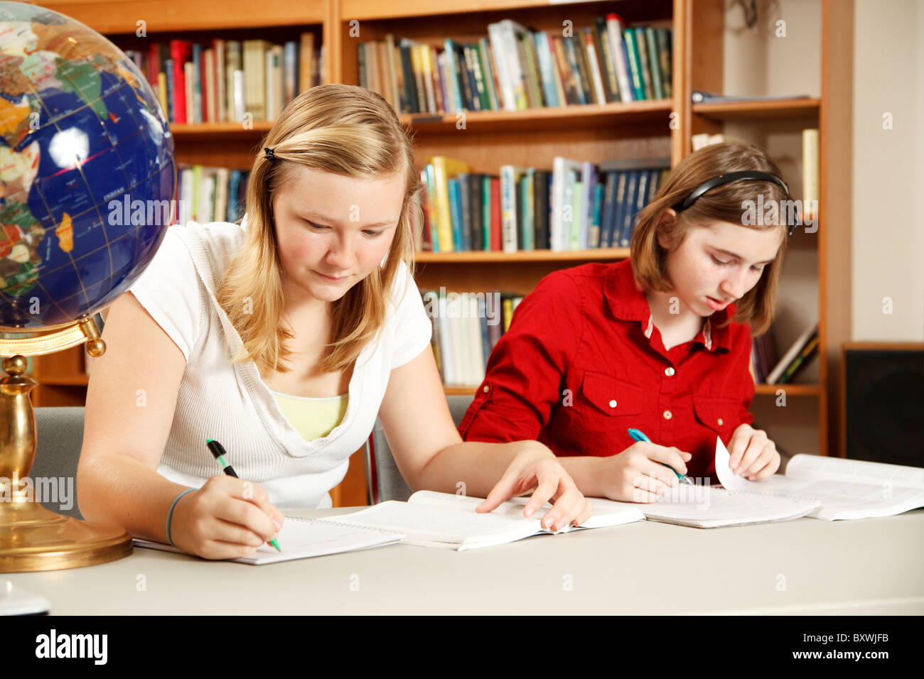 Serious teenage girls doing research in the school library Stock Photo ...
