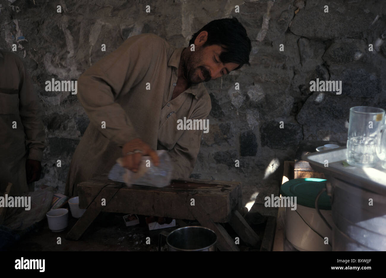 Pakistani man from Northern Areas shaving block of glacier ice from ...