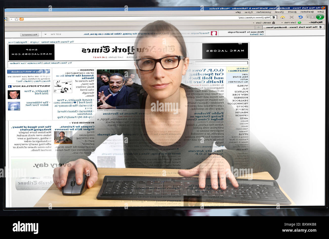 Woman is sitting in front of a computer, surfing the Internet, view ...