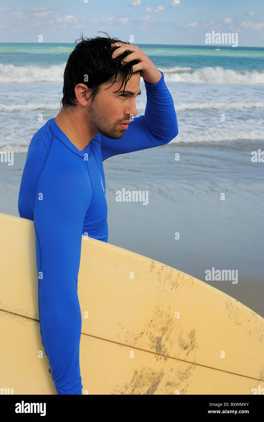Surfer running on the beach into the ocean with his board Stock Photo ...